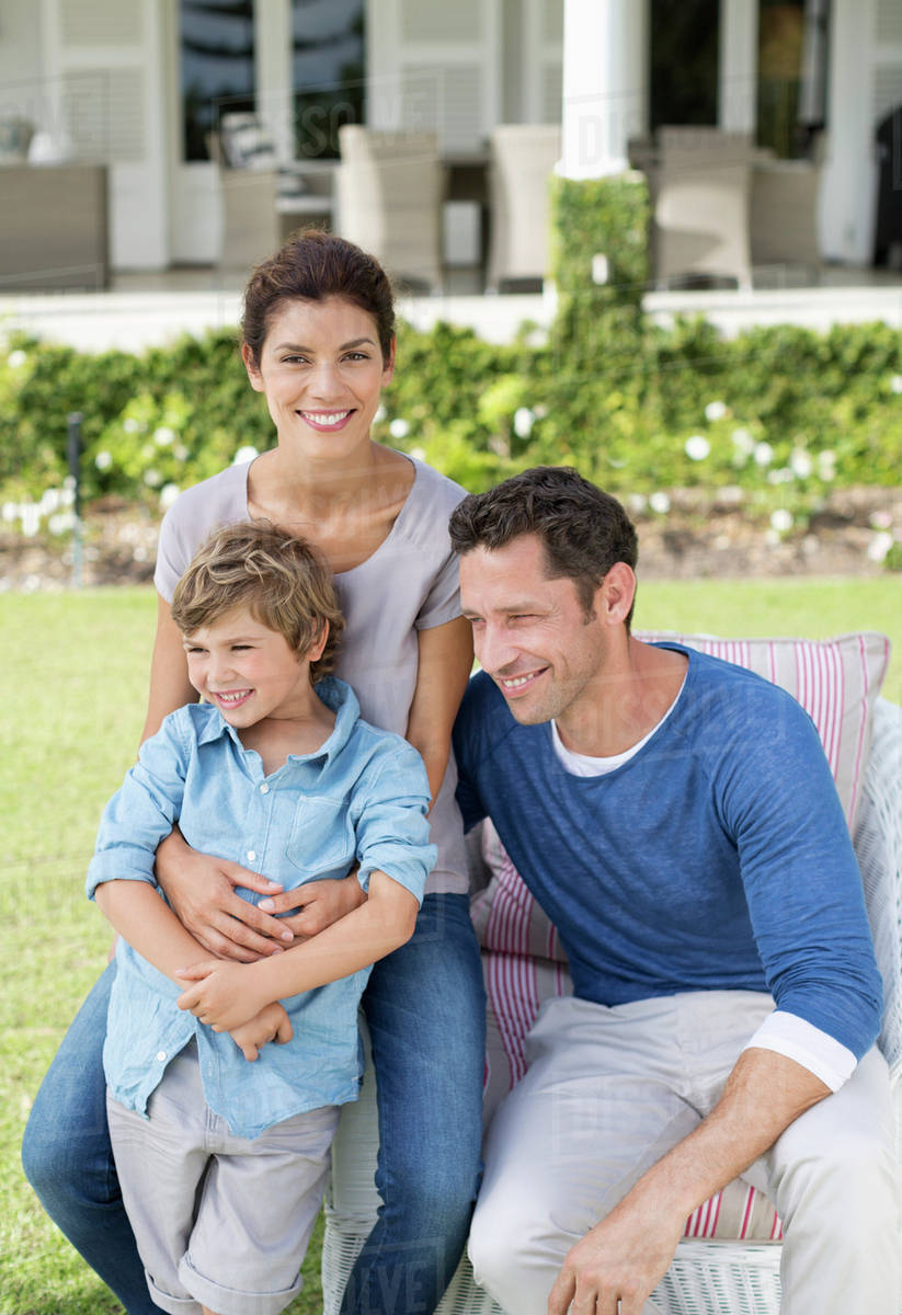 Family smiling outside house - Stock Photo - Dissolve