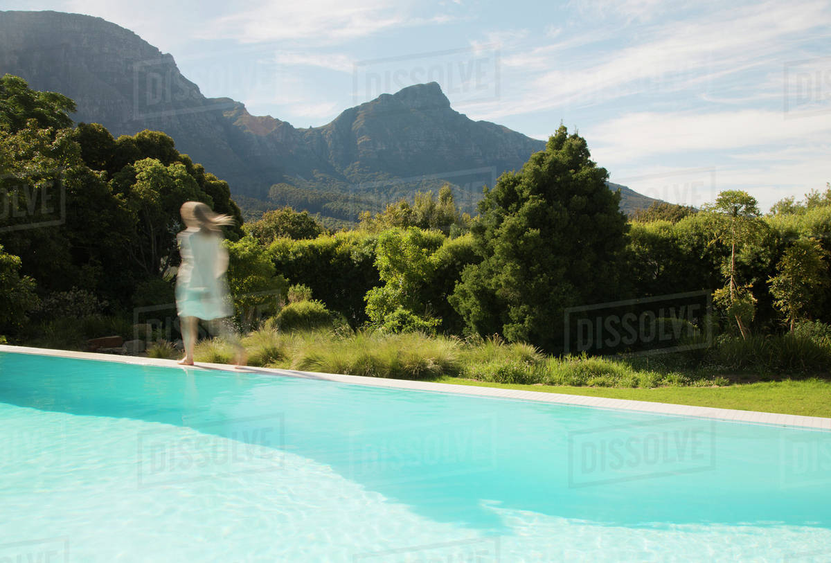 Woman walking along swimming pool - Royalty-free Stock Photo | Dissolve