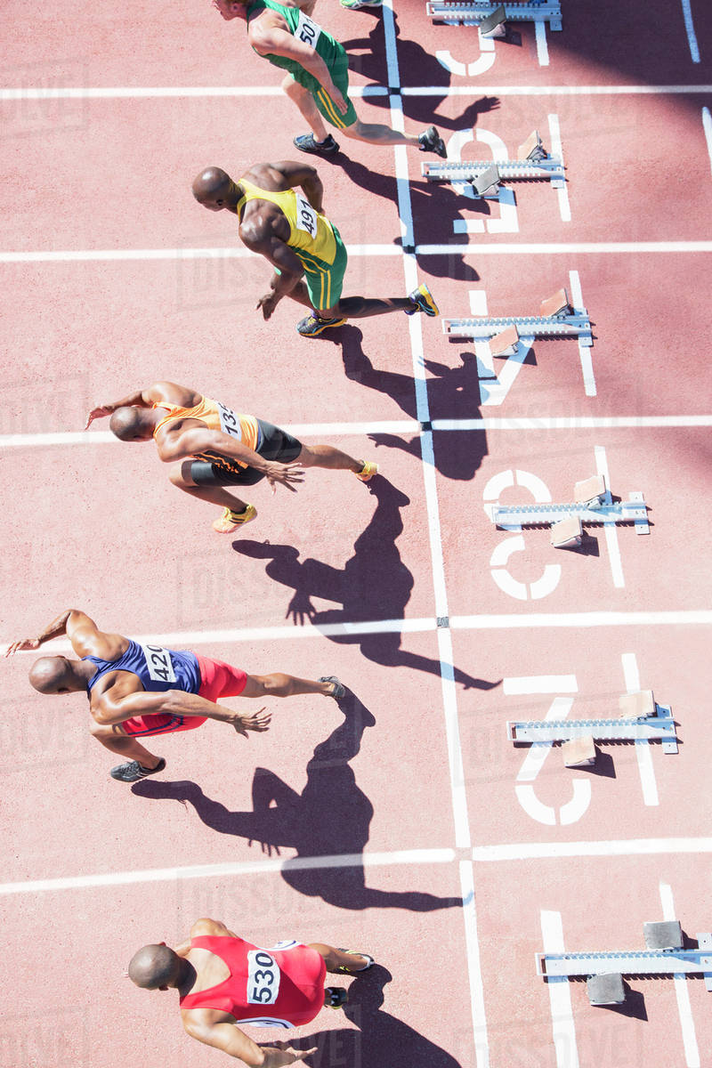Sprinters taking off from starting blocks on track - Royalty-free Stock ...