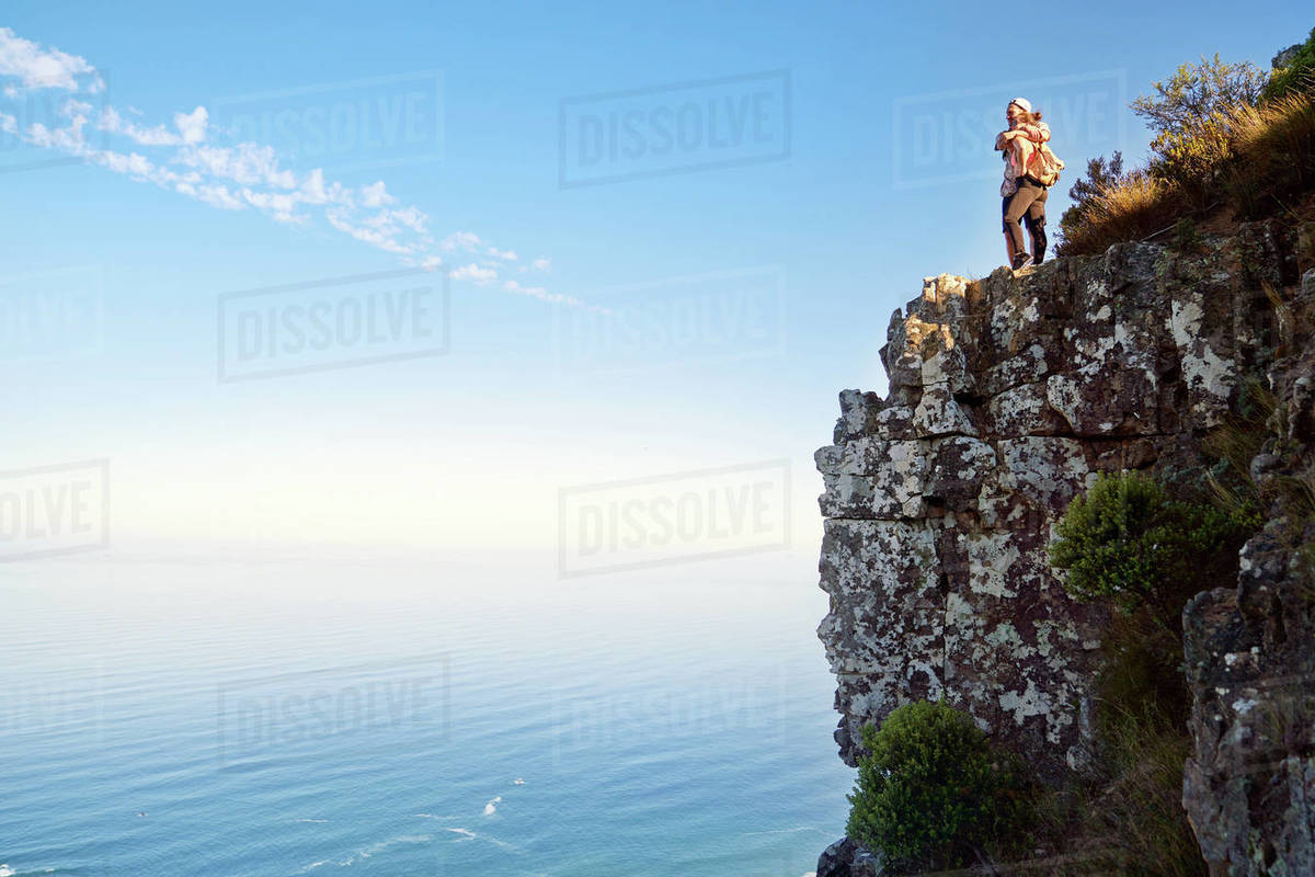 Couple hugging on cliff over sunny ocean Cape Town South Africa ...
