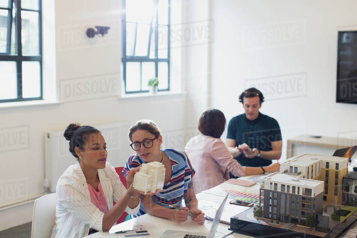 Architects examining model in conference room meeting - Royalty-free ...