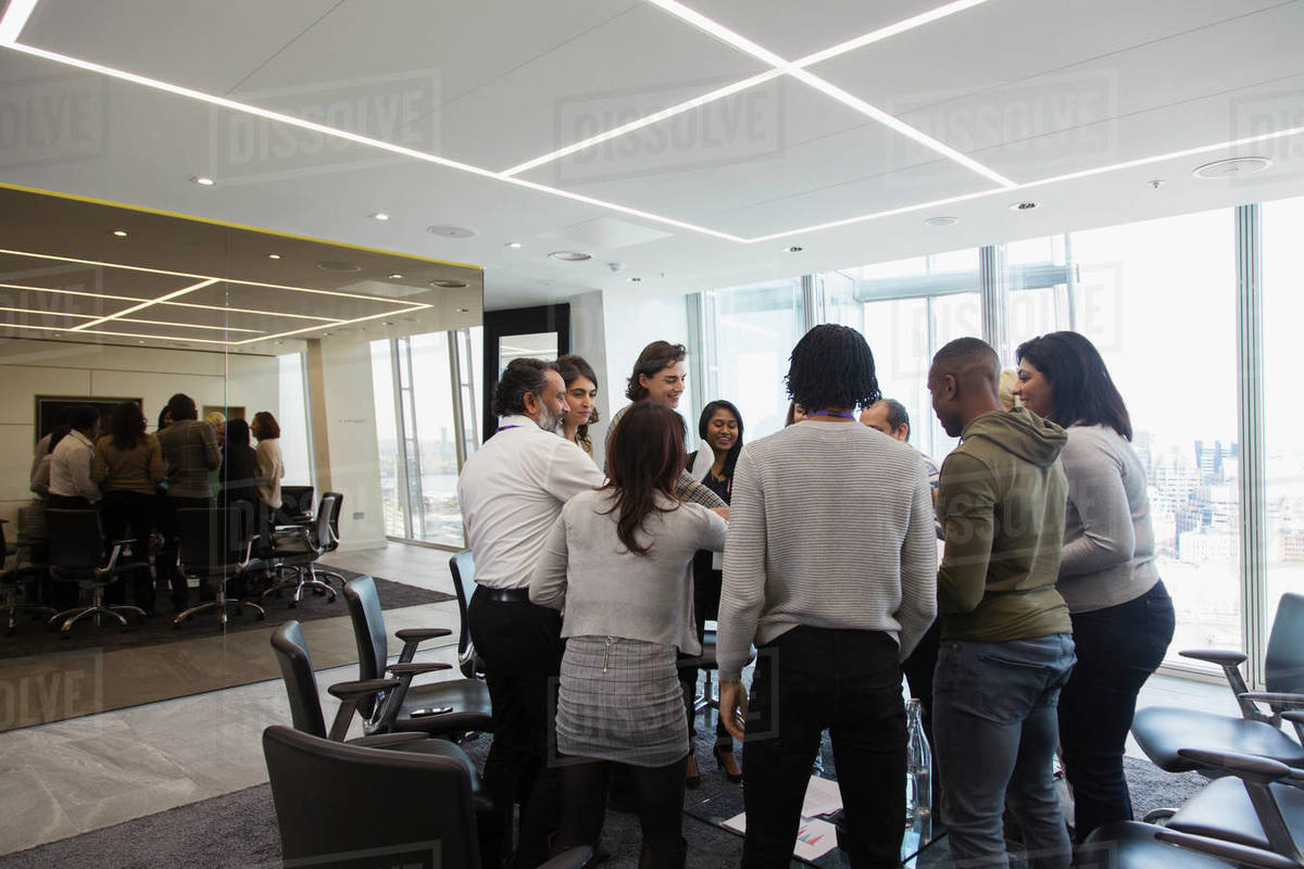 Business people standing in huddle in office - Royalty-free Stock Photo ...
