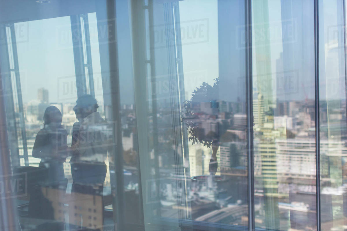 Reflection of city in highrise office window - Stock Photo - Dissolve