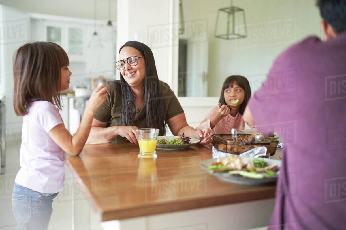 Happy family eating lunch at table - Royalty-free Stock Photo | Dissolve