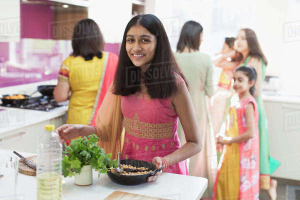 Portrait happy Indian girl in sari cooking food in kitchen - Stock ...