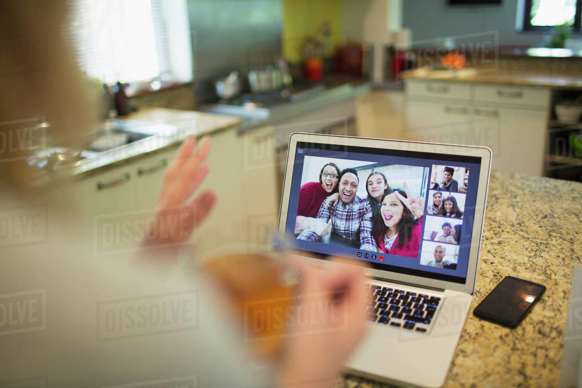 Friends video chatting on laptop screen in kitchen - Stock Photo - Dissolve