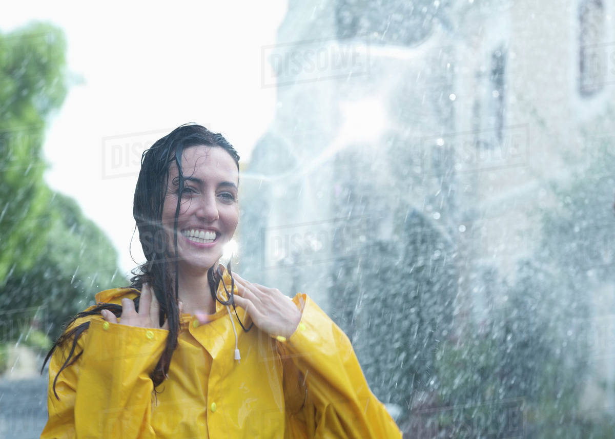 Enthusiastic woman standing in rain - Royalty-free Stock Photo | Dissolve