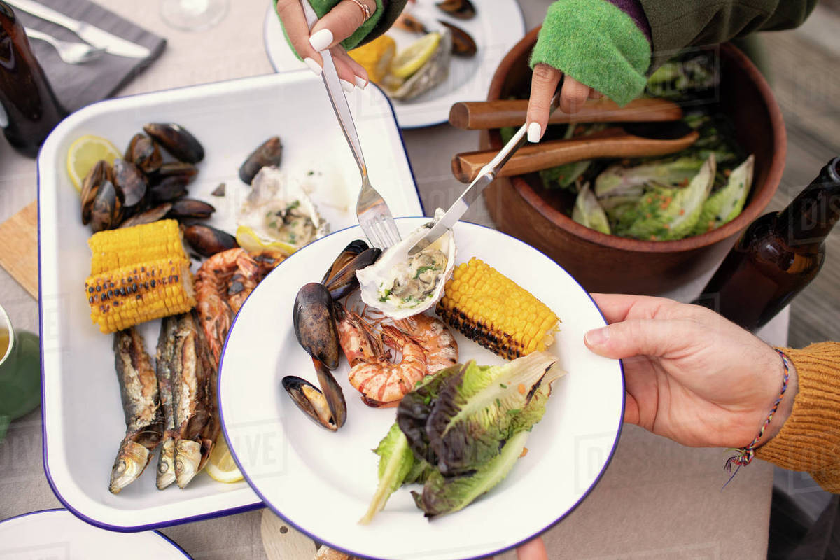 View from above couple serving fresh seafood at patio table - Royalty ...