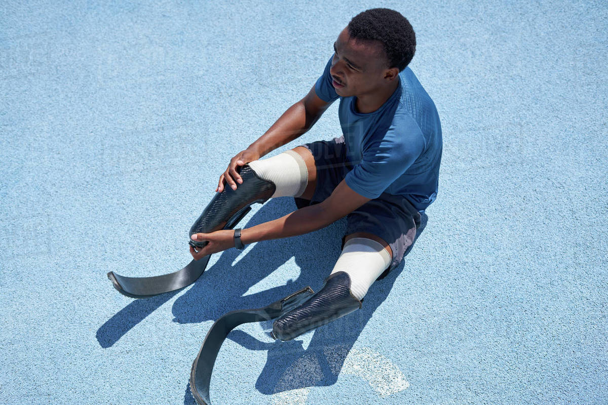 Male amputee sprinter preparing on blue sports track - Royalty-free ...