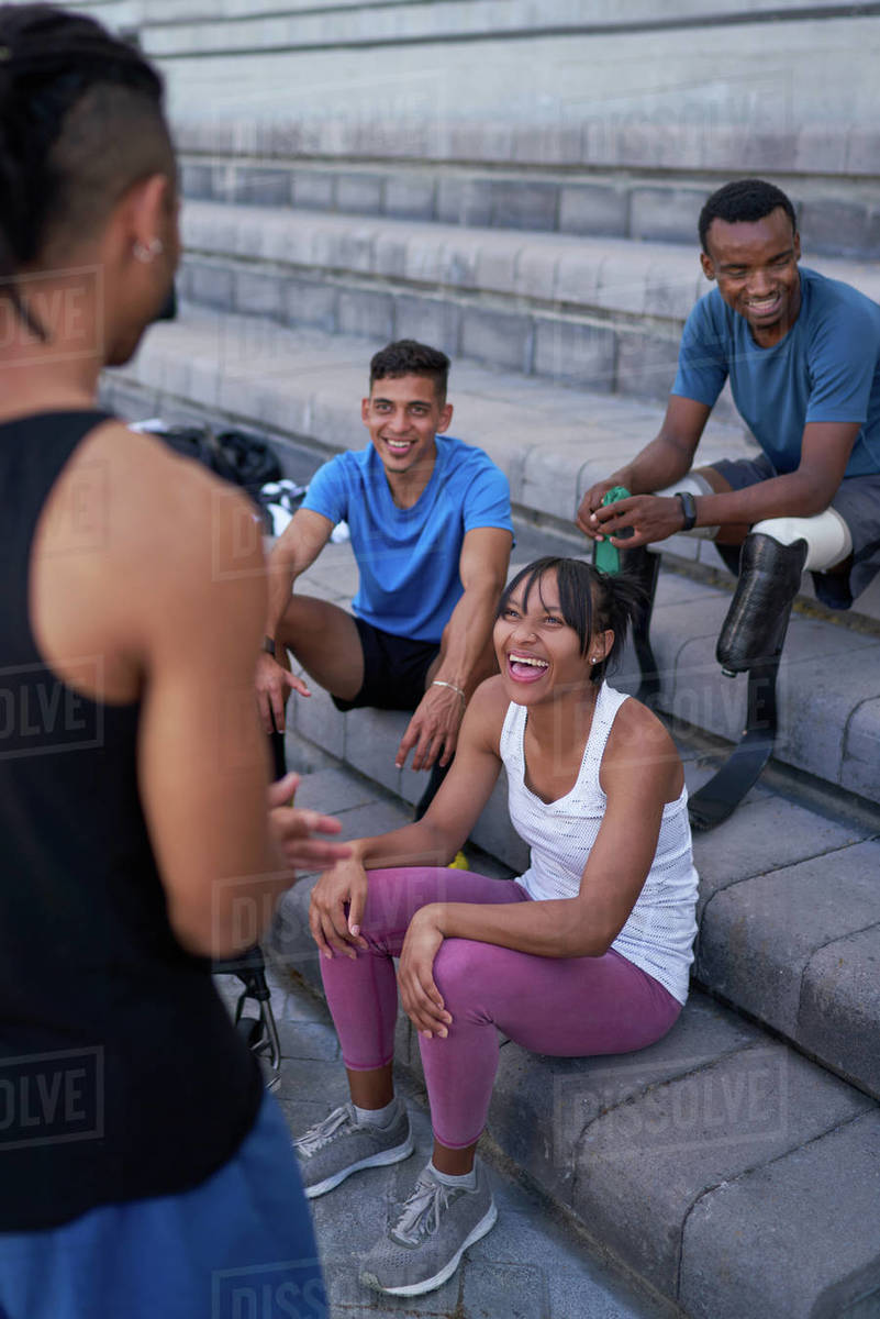 Happy athletes talking on steps - Stock Photo - Dissolve