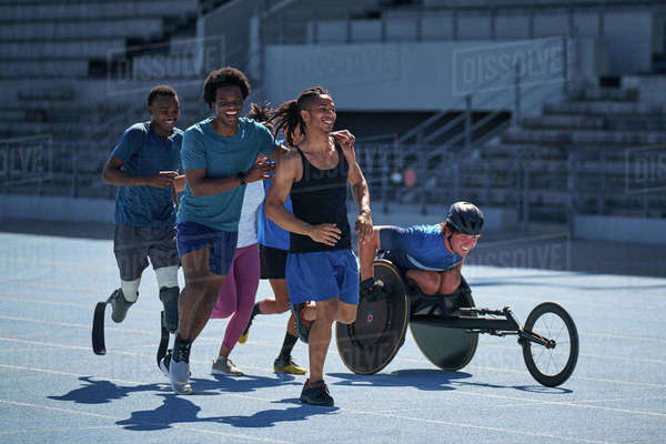 Happy diverse athletes running on sunny sports track - Royalty-free ...