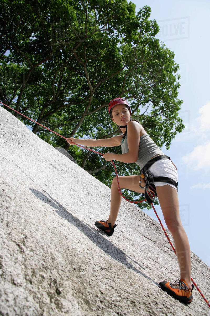 Woman rock climbing or repelling - Stock Photo - Dissolve