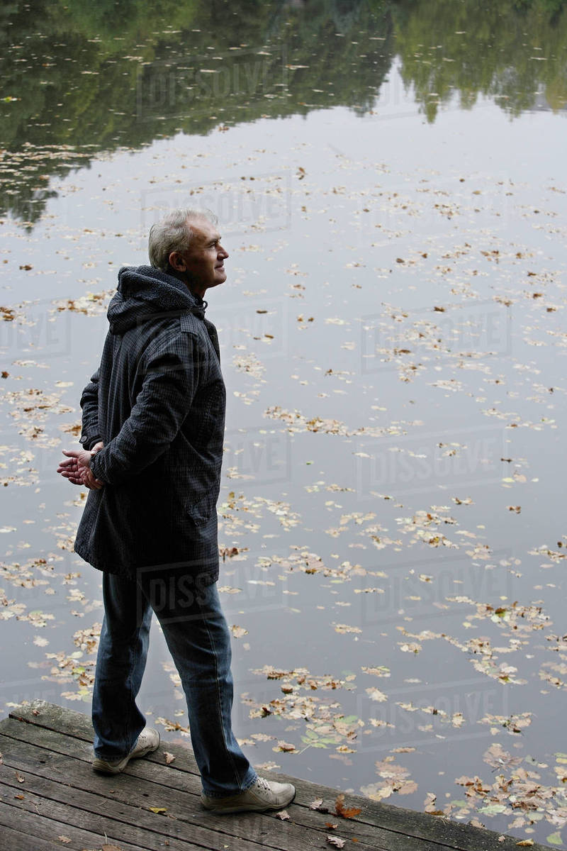 Senior man overlooking pond - Royalty-free Stock Photo | Dissolve