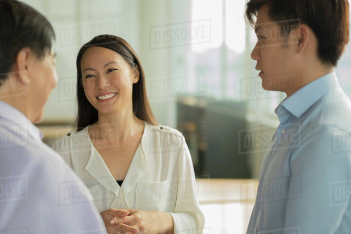 Three people talking in office - Stock Photo - Dissolve