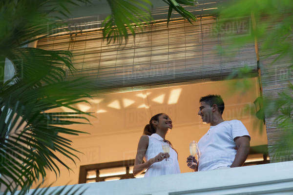 Two young people standing on balcony, holding champagne - Royalty-free ...