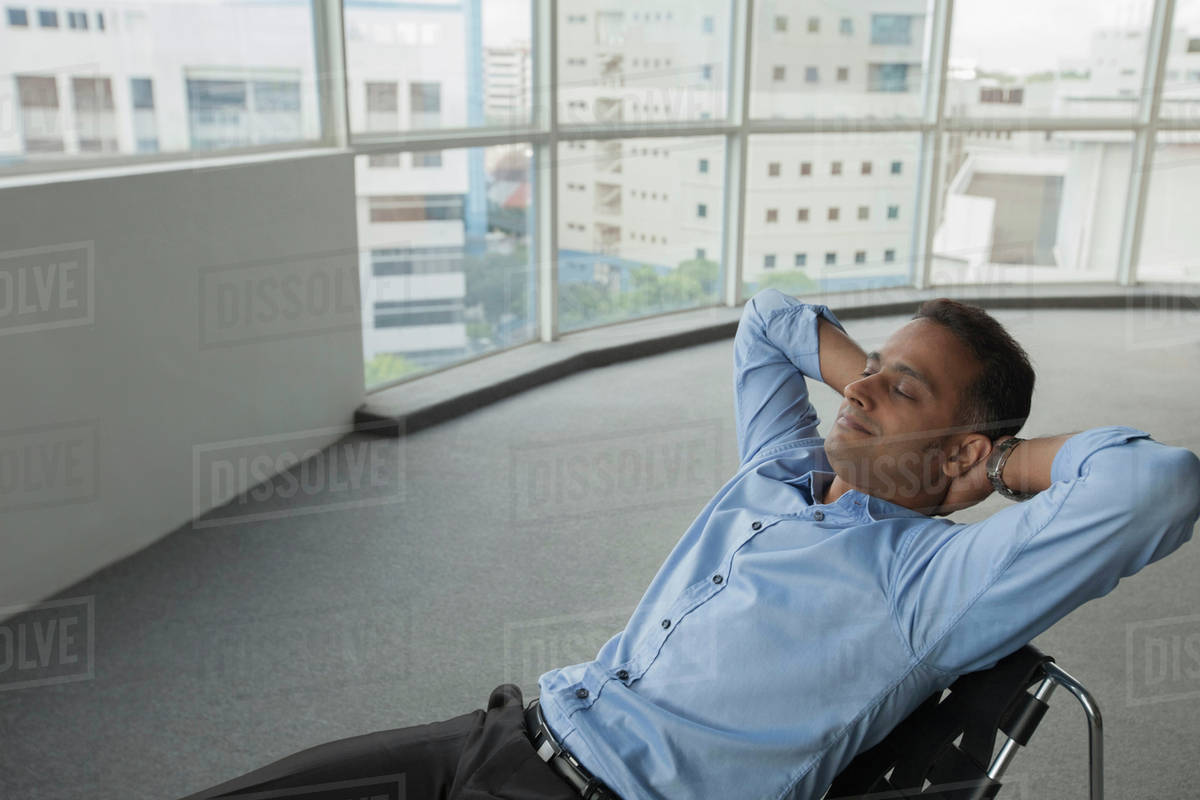 Businessman reclining in chair in empty office - Royalty-free Stock ...