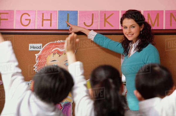 Teacher teaching alphabet in class - Royalty-free Stock Photo | Dissolve