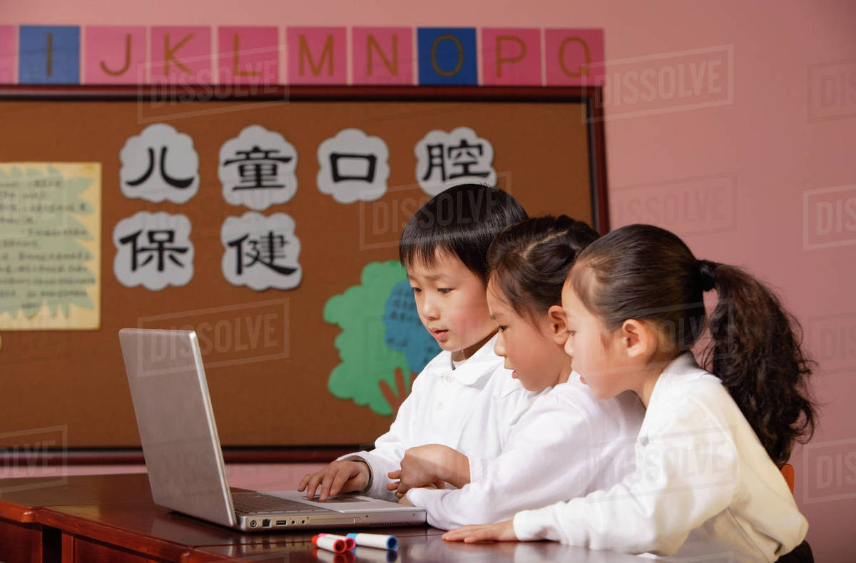 Young students using laptop in class - Royalty-free Stock Photo | Dissolve