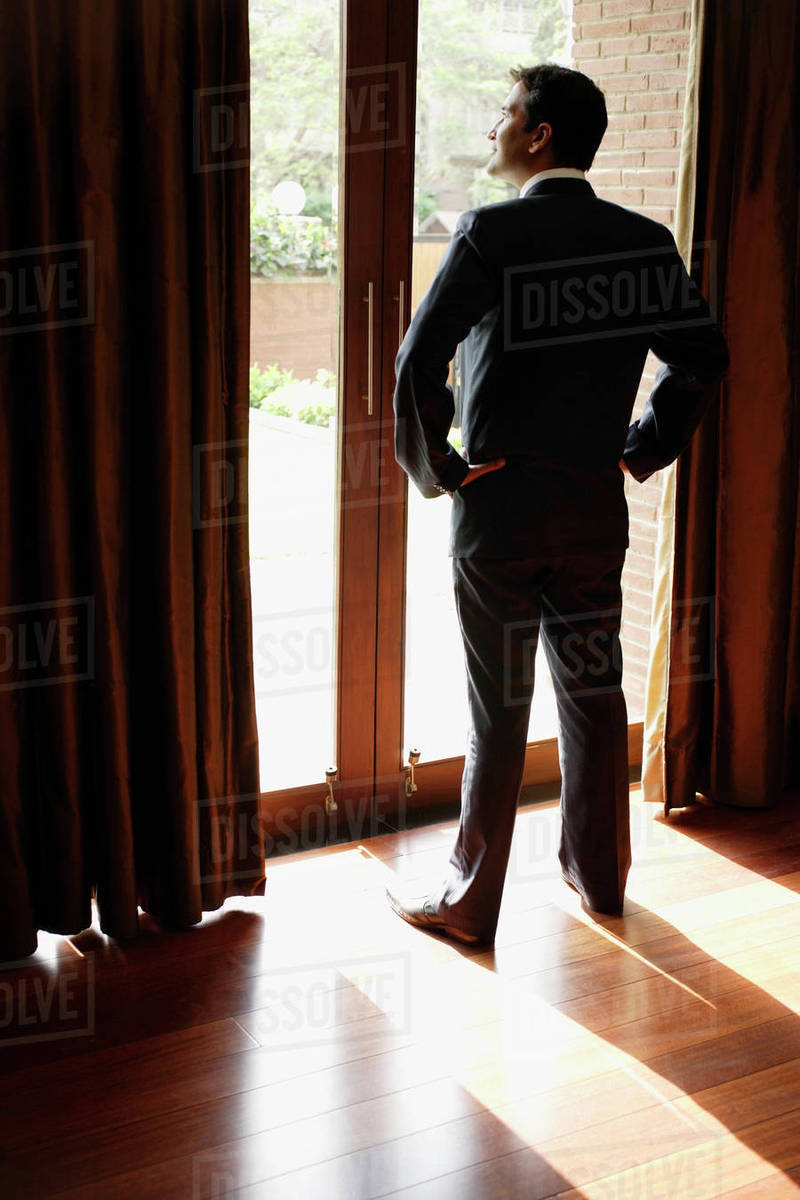 Man standing at window - Royalty-free Stock Photo | Dissolve