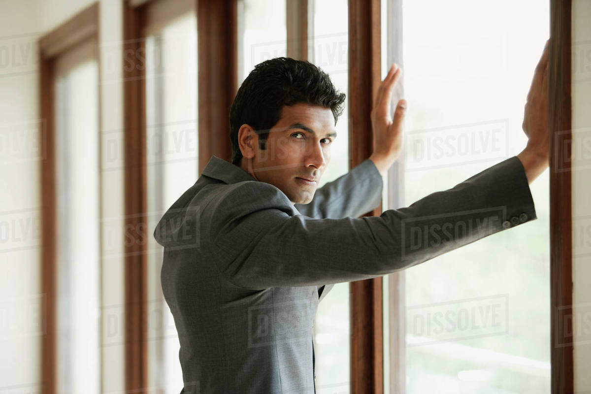 Businessman with hands on window - Stock Photo - Dissolve