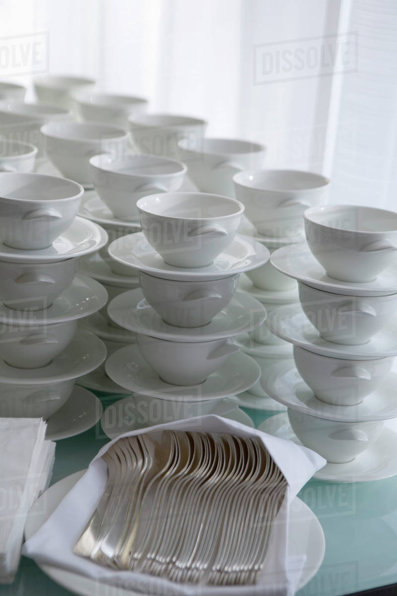 A large amount of spoons and stacked cups and saucers - Stock Photo ...