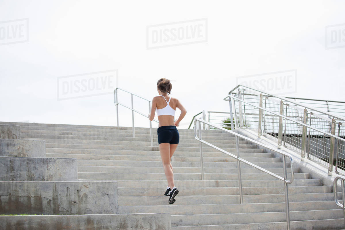 Girl jogging up steps - Stock Photo - Dissolve