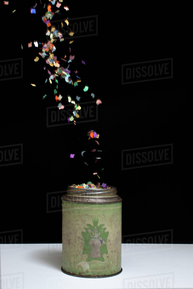 An old-fashioned metal tin and floating confetti - Stock Photo - Dissolve