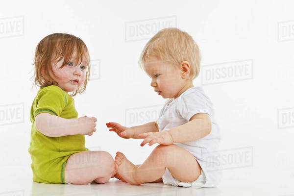 Two babies sitting together - Royalty-free Stock Photo | Dissolve