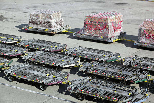 Empty baggage trailers and cargo on an airport tarmac - Royalty-free ...