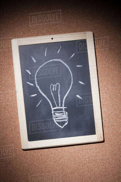 An illuminated light bulb drawn in chalk on a small chalkboard ...