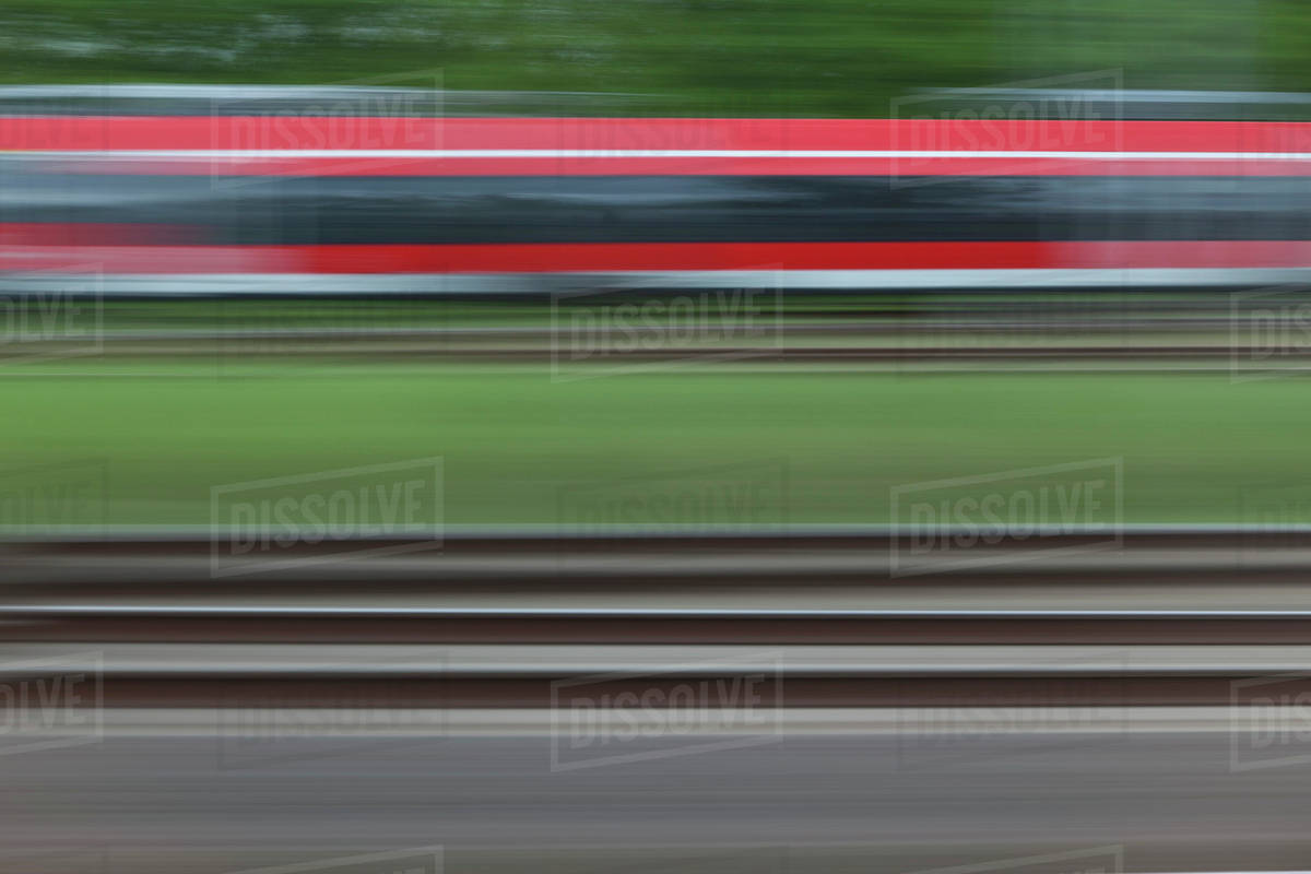 Railroad tracks and a train, blurred motion, viewed from a moving train ...