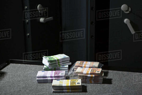 Stacks of large billed Euro banknotes on a table outside of a vault ...