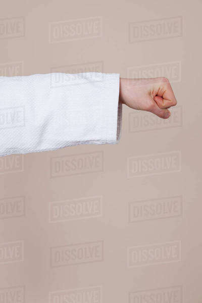 A girl in a martial arts fighting stance, close-up of arm and fist ...