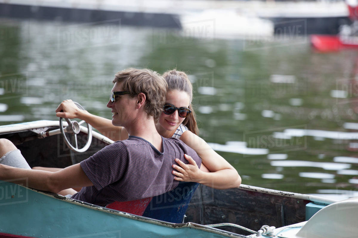 Young couple riding paddle boat on lake - Stock Photo - Dissolve