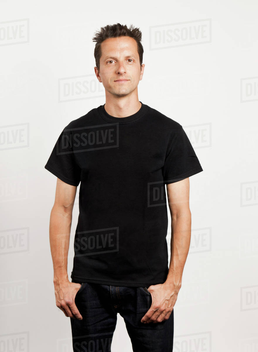 Portrait of young man standing against white background - Stock Photo ...