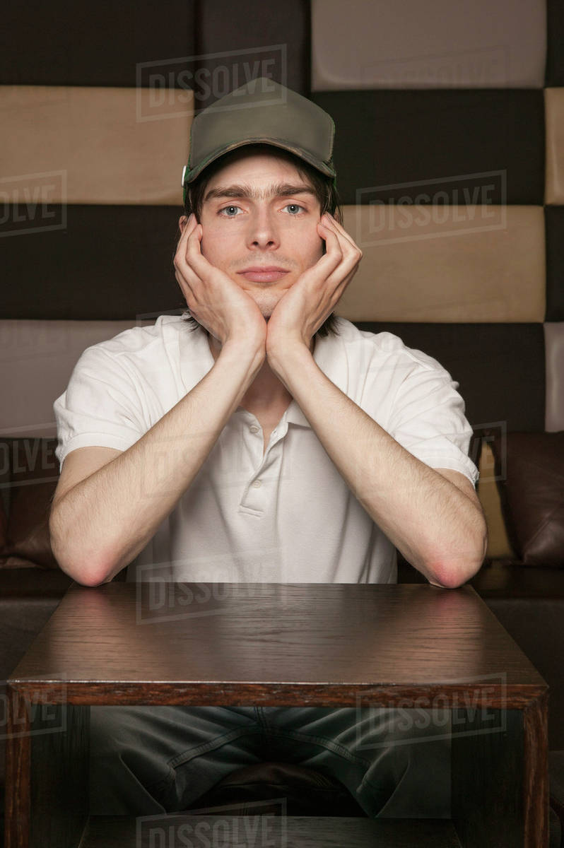 Portrait of a sad man sitting at a table - Royalty-free Stock Photo ...