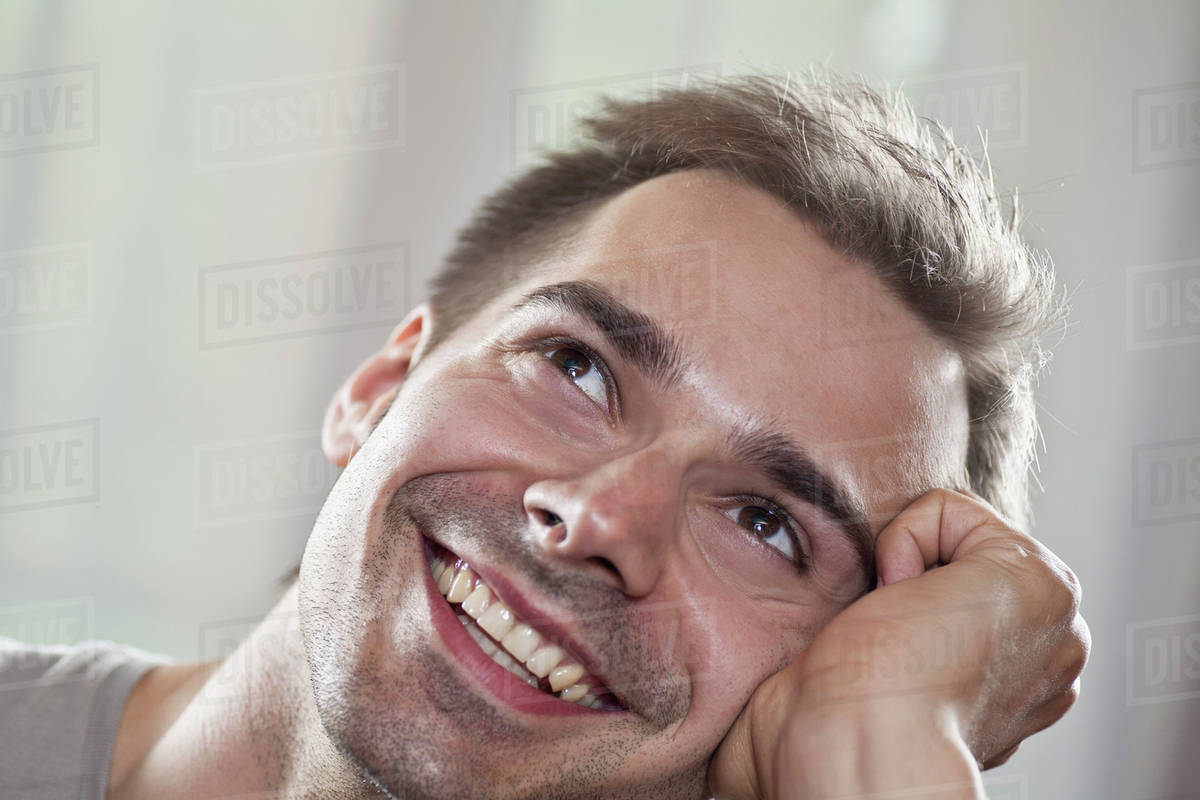 Young man looking up and smiling, close-up - Royalty-free Stock Photo ...