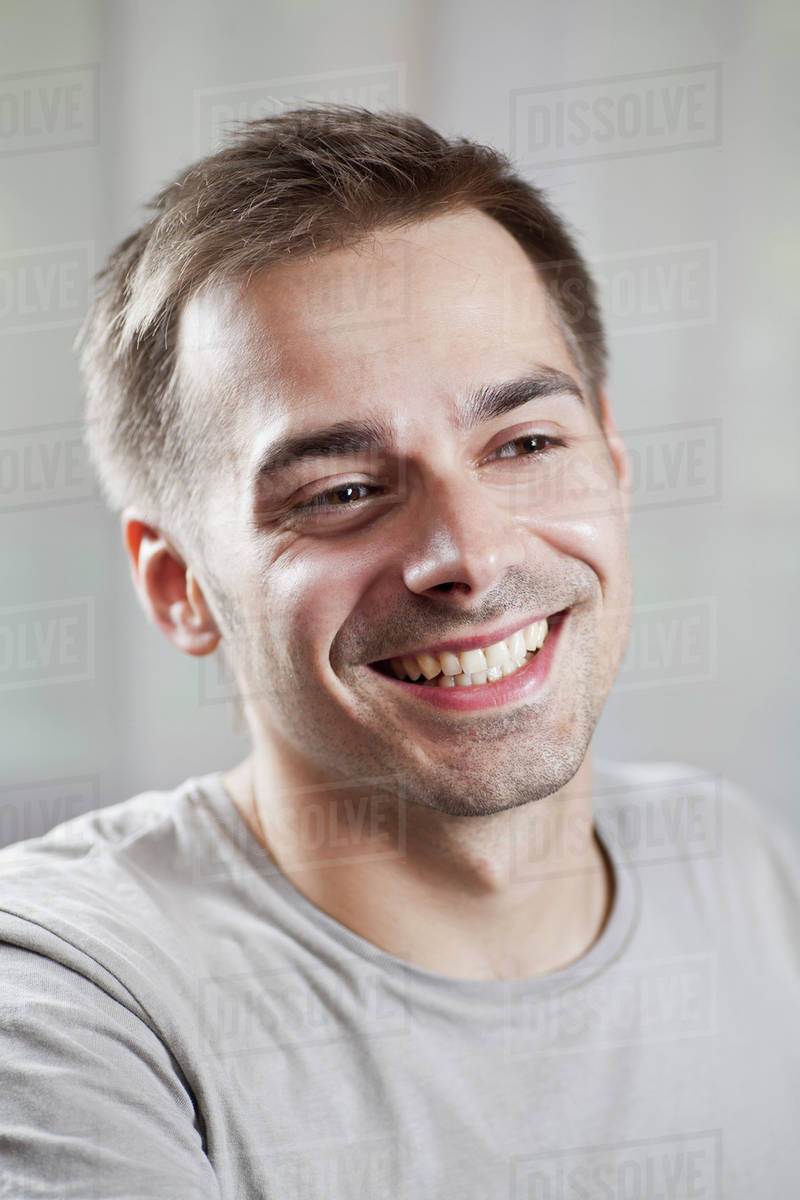Young man looking away and smiling, close-up - Royalty-free Stock Photo ...