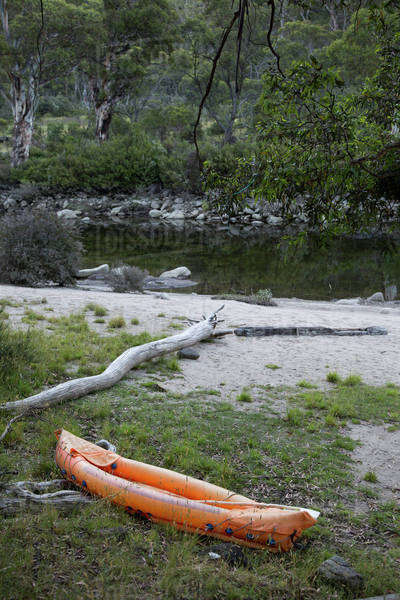 Abandoned inflatable raft on lakeshore - Stock Photo - Dissolve