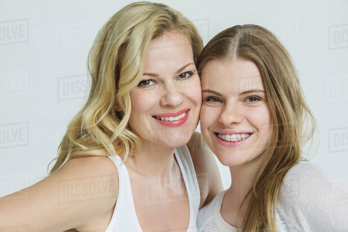 Portrait of happy female friends smiling isolated over white background ...