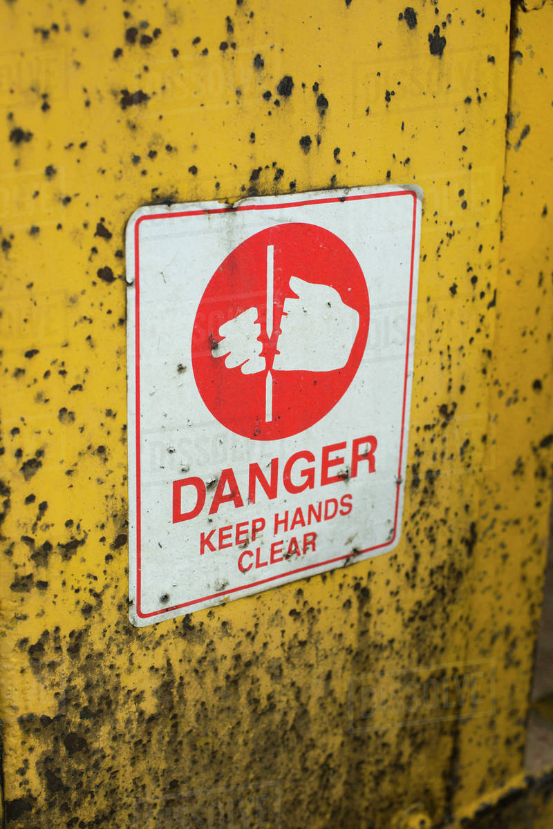 Warning sign on yellow wall outdoors - Stock Photo - Dissolve