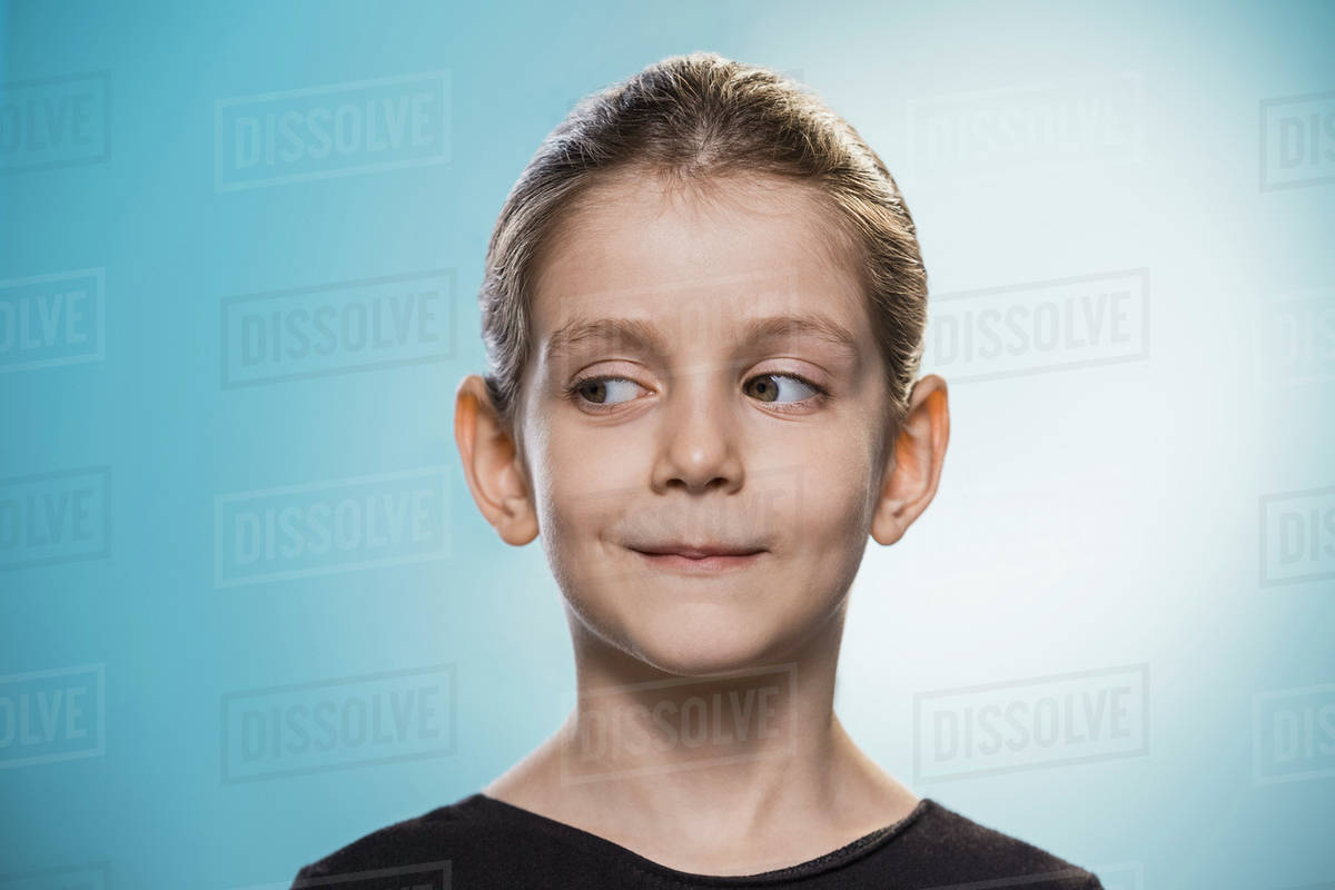 Cute girl looking sideways over blue background - Stock Photo - Dissolve