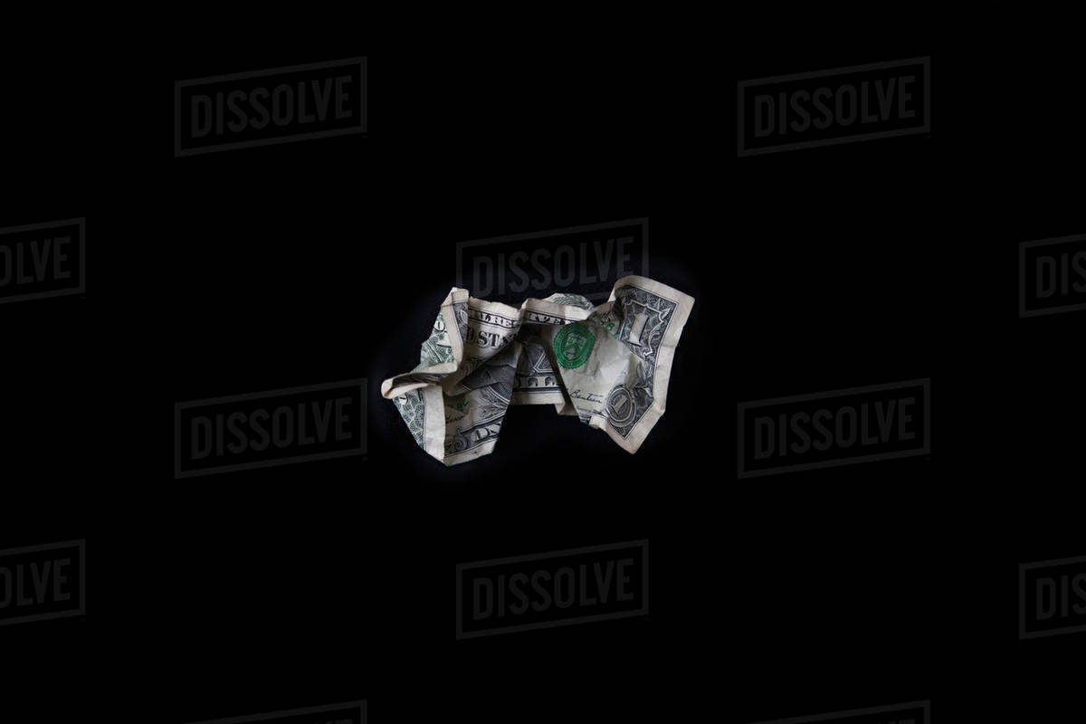 Crumpled dollar bill on black background - Stock Photo - Dissolve