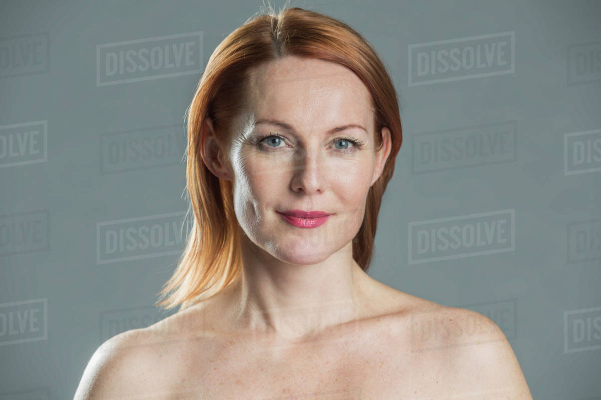 Portrait of topless woman against gray background - Stock Photo - Dissolve