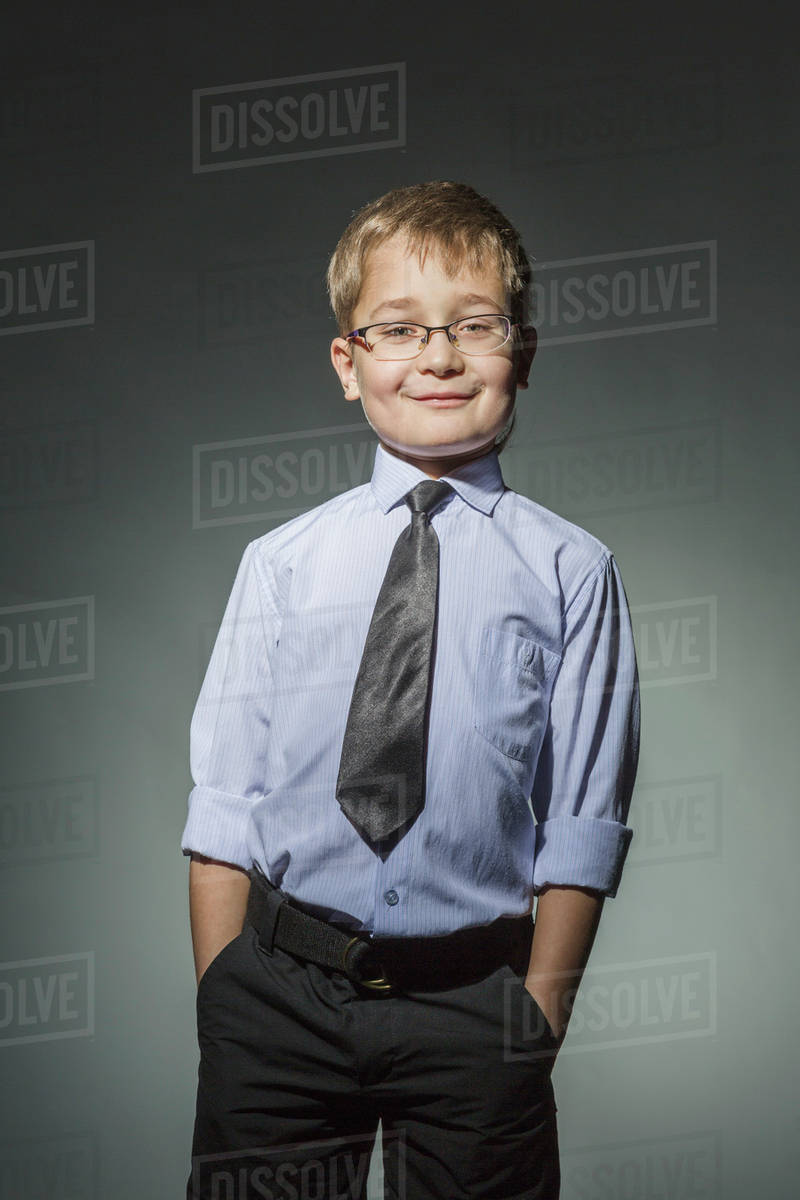 Portrait of well-dressed boy standing against gray background - Stock ...