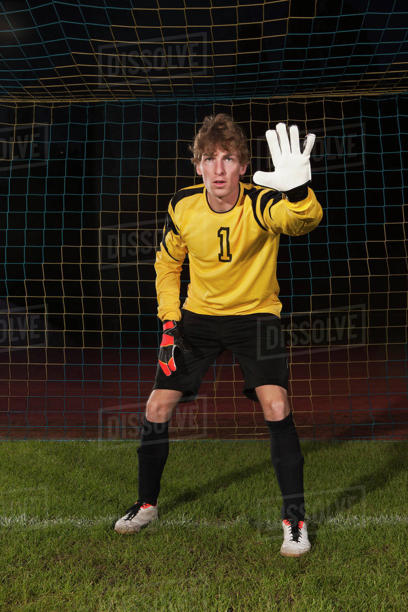 Portrait of confident goalie defending soccer net on field - Stock ...