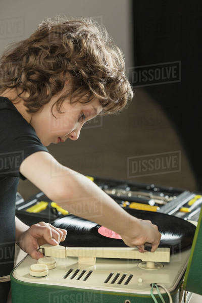 Boy playing vinyl record at home - Royalty-free Stock Photo | Dissolve