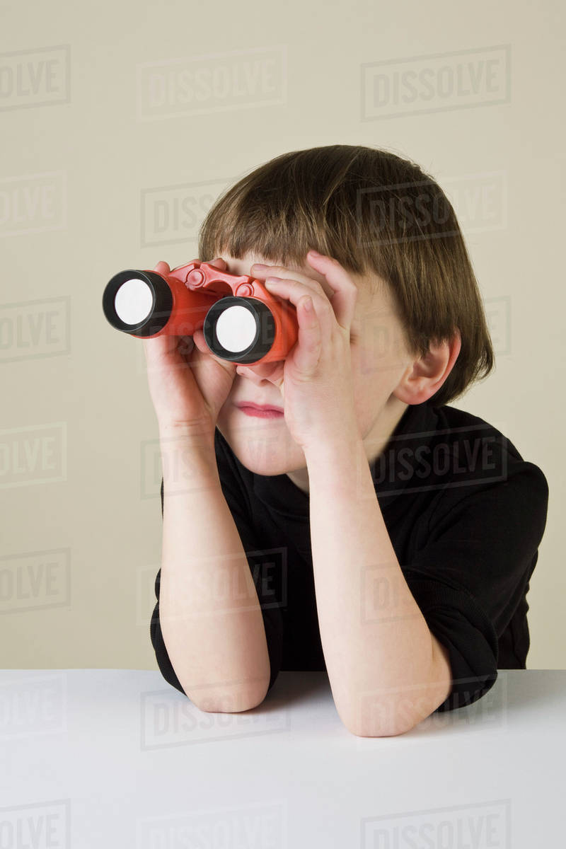 A boy using binoculars - Stock Photo - Dissolve