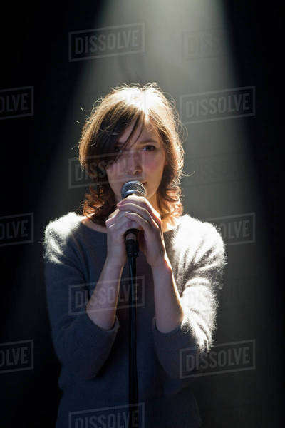 A Woman Standing Behind A Microphone - Royalty-free Stock Photo | Dissolve