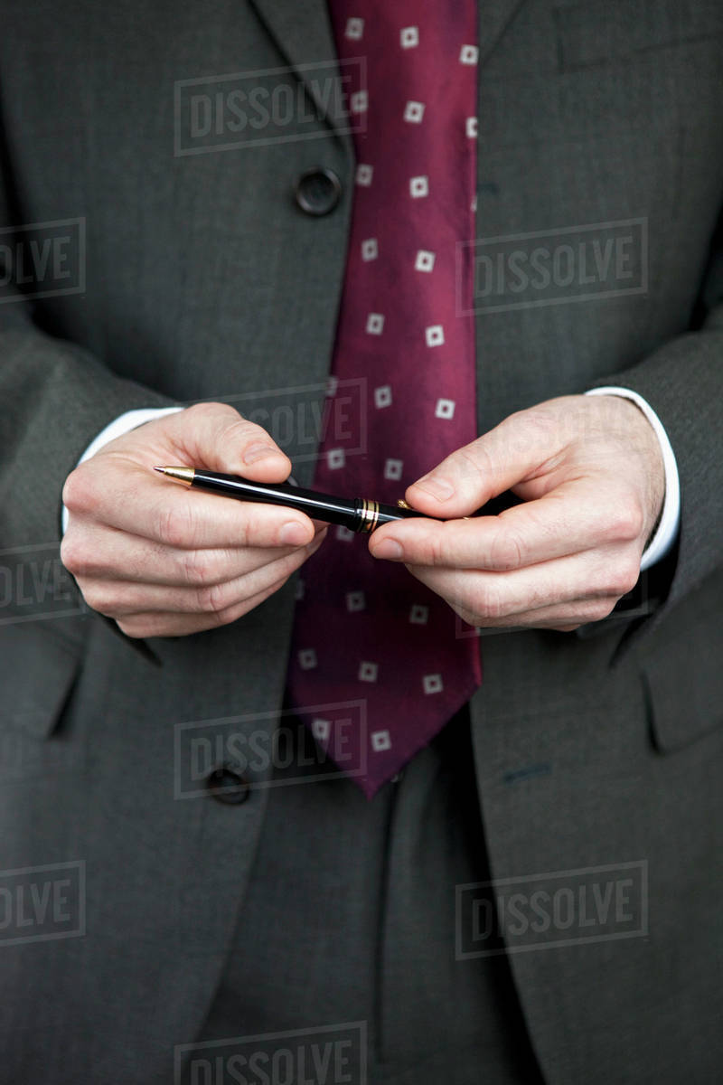 Businessman holding pen close up - Royalty-free Stock Photo | Dissolve